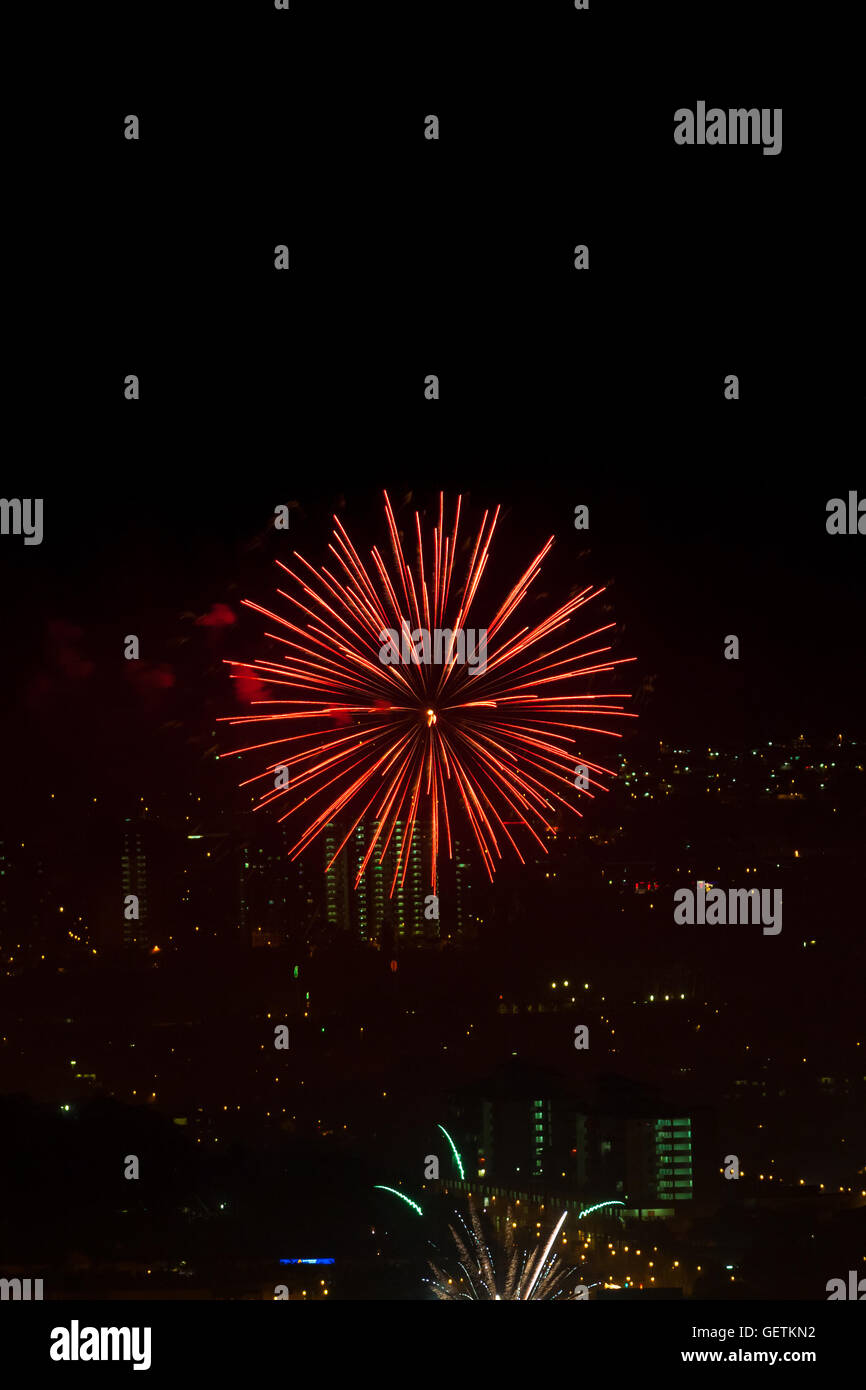 single red fireworks burst over city lights Stock Photo - Alamy