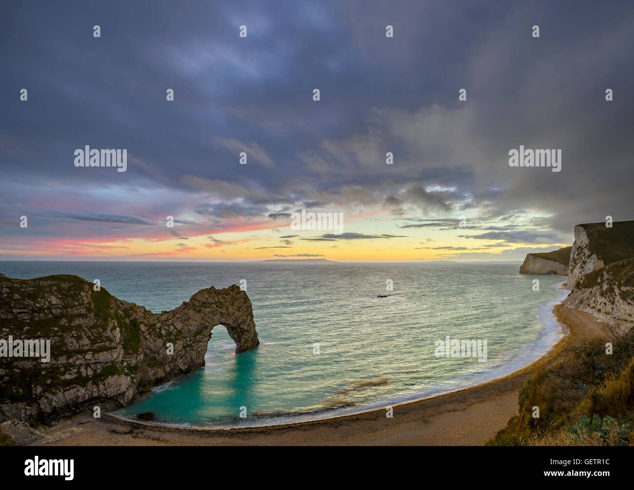 The natural limestone arch of Durdle Door at sunset Stock Photo - Alamy