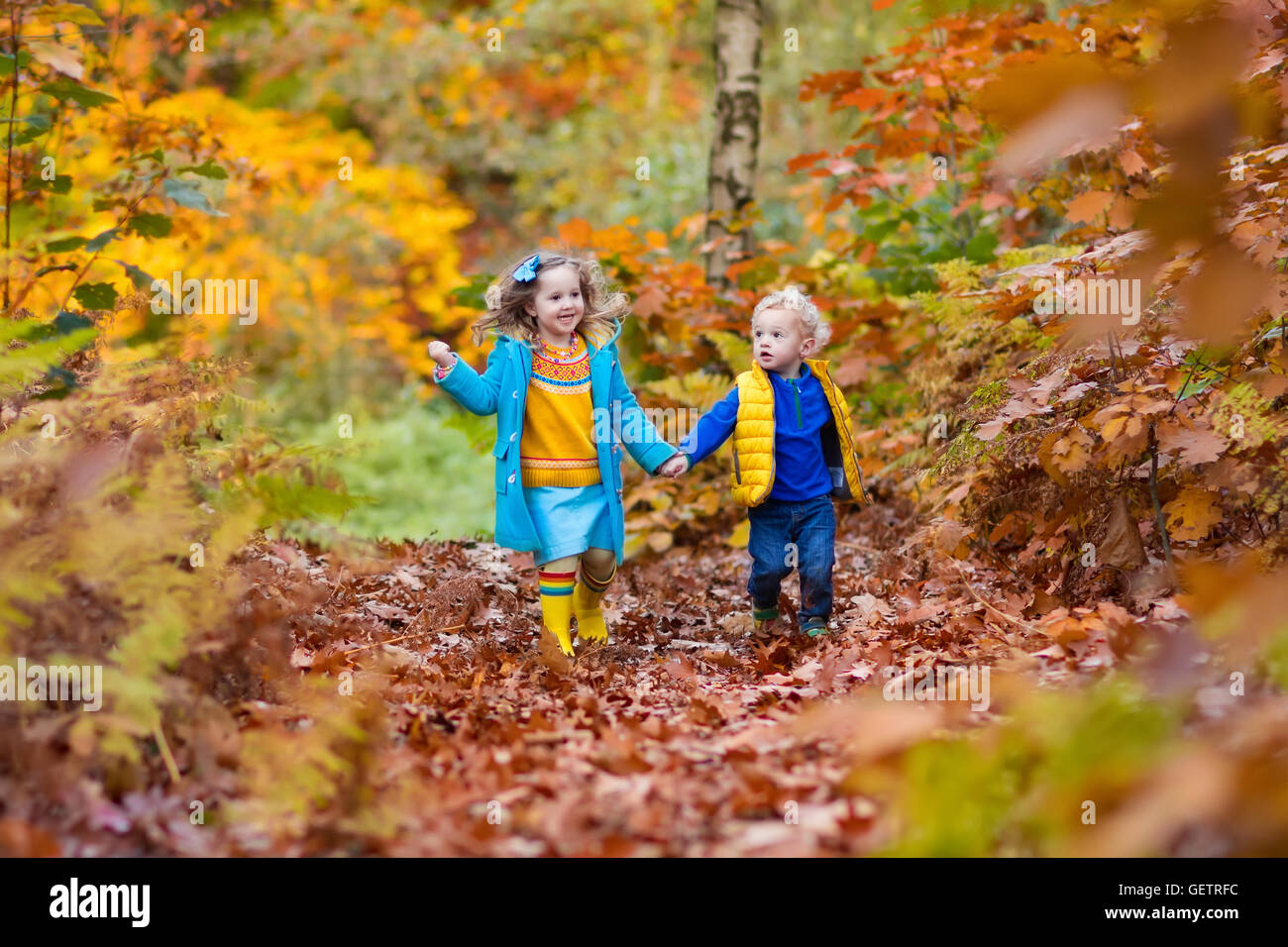 Happy children playing in beautiful autumn park on warm sunny fall day ...