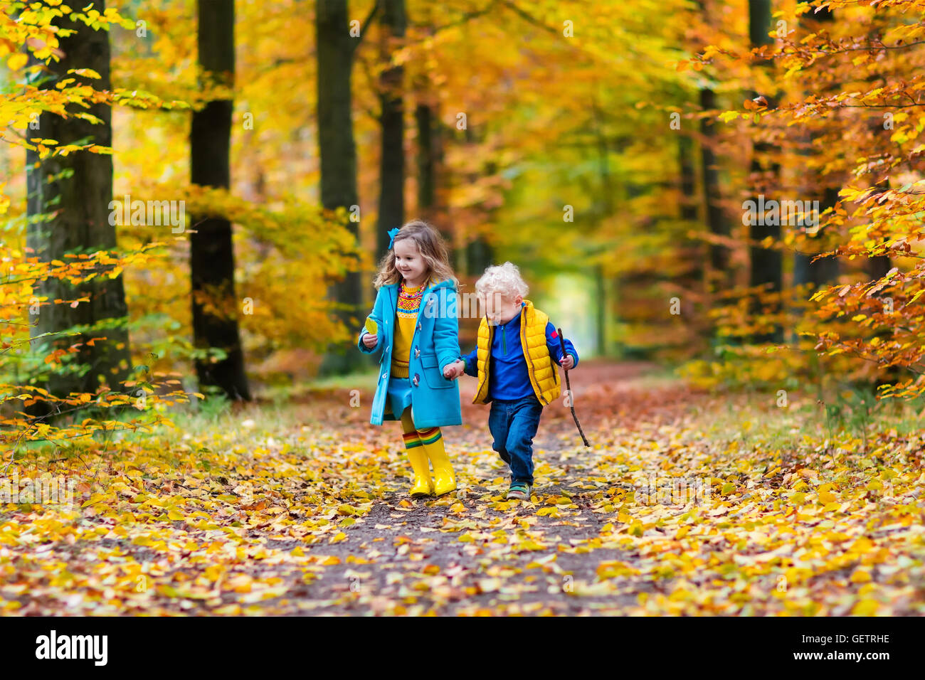 Happy children playing in beautiful autumn park on warm sunny fall day ...