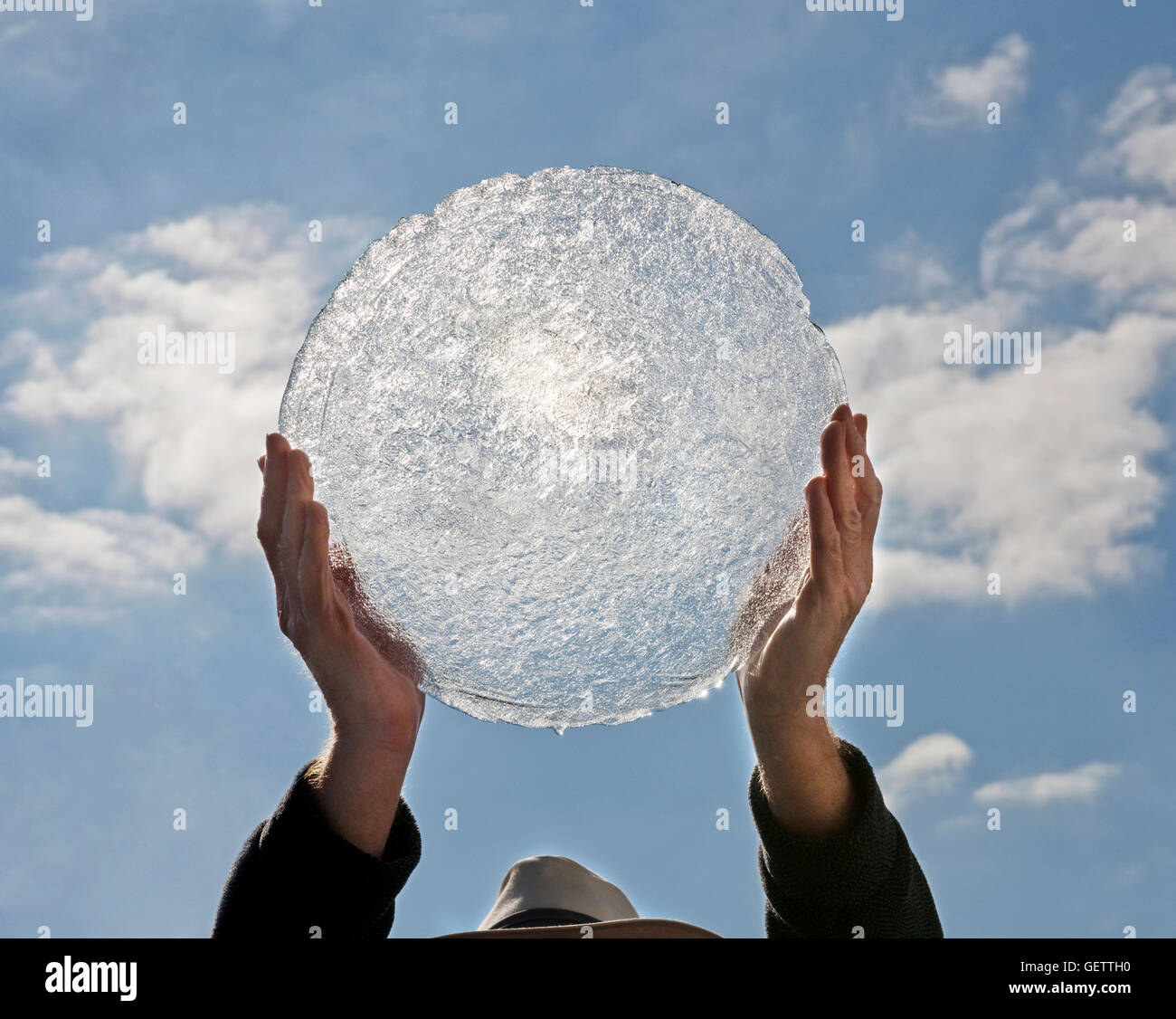 Disc of ice held up to catch the winter sunlight Stock Photo - Alamy