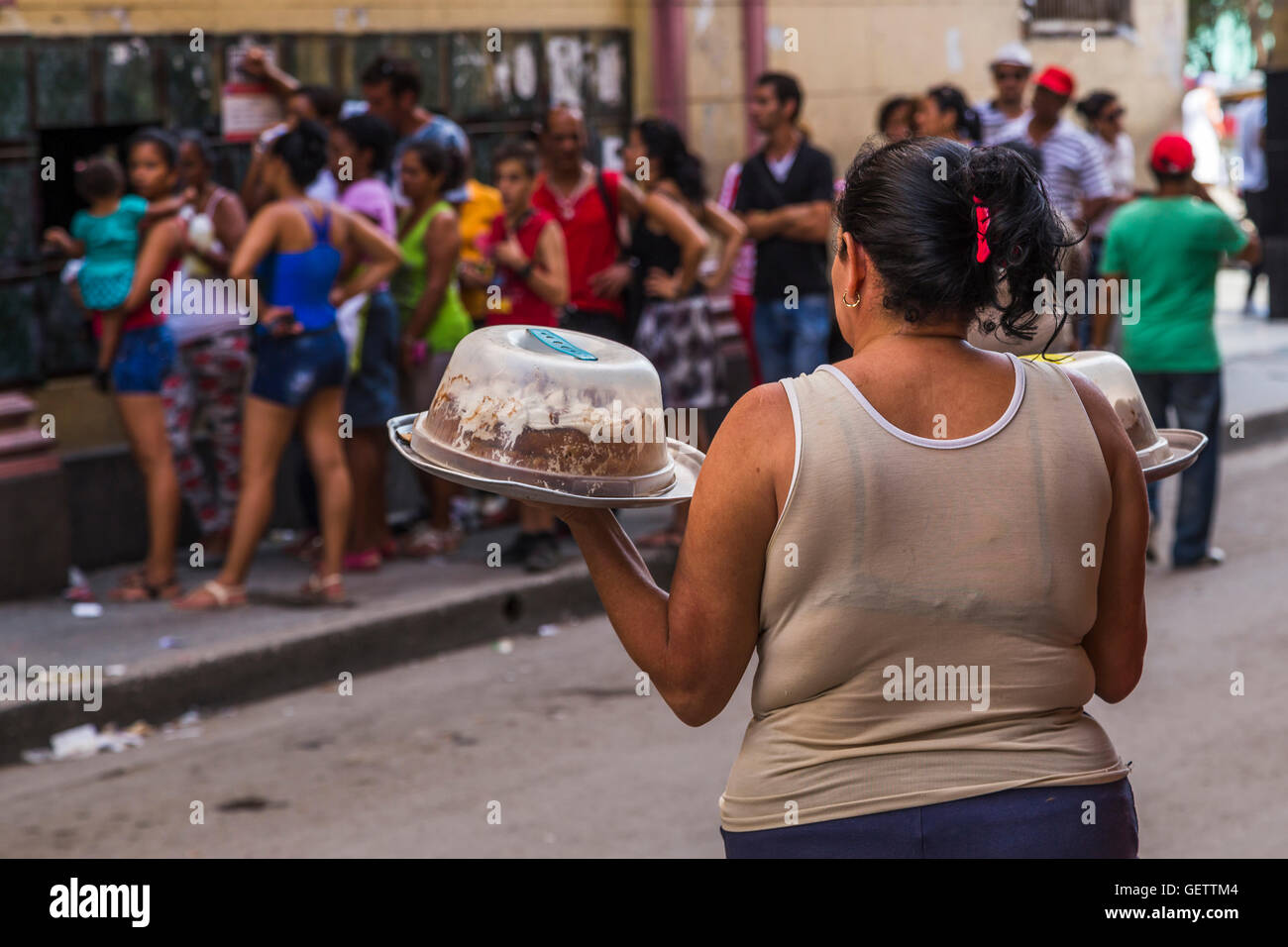 A woman carrying two cakes in Havana Stock Photo - Alamy
