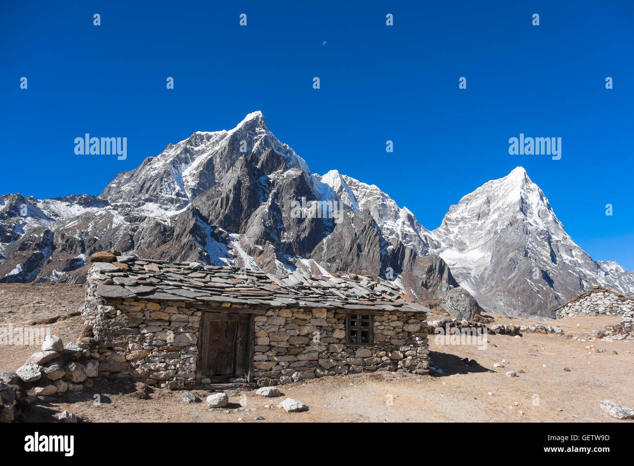 Traditional Nepalese stone house with the Himalayan peaks of Taboche ...