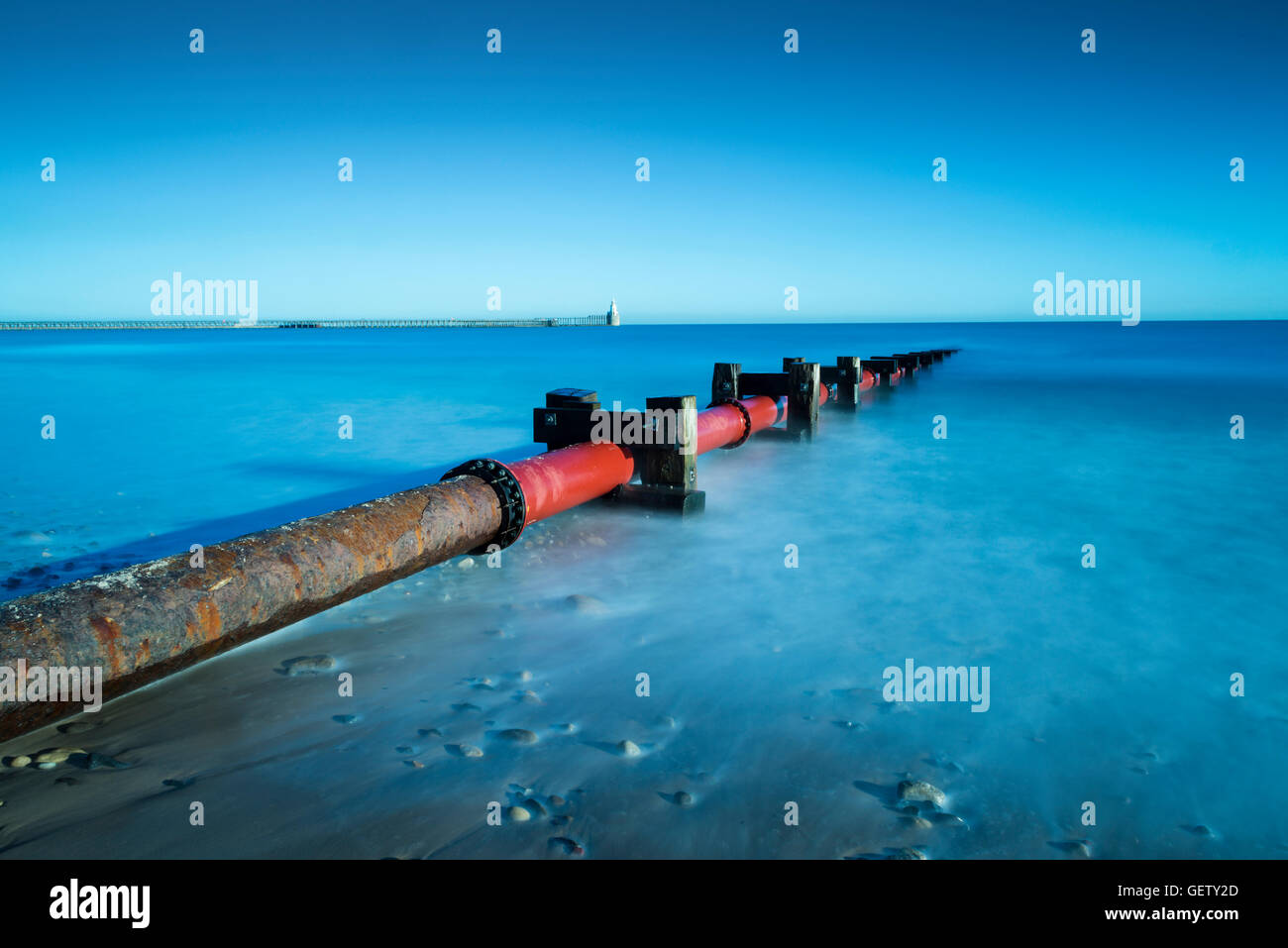 An old pipe reaching out from the beach to the North Sea at Blyth beach ...