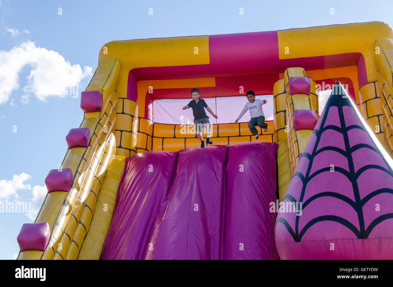 Young children at the top of a large, inflatable slide Stock Photo - Alamy