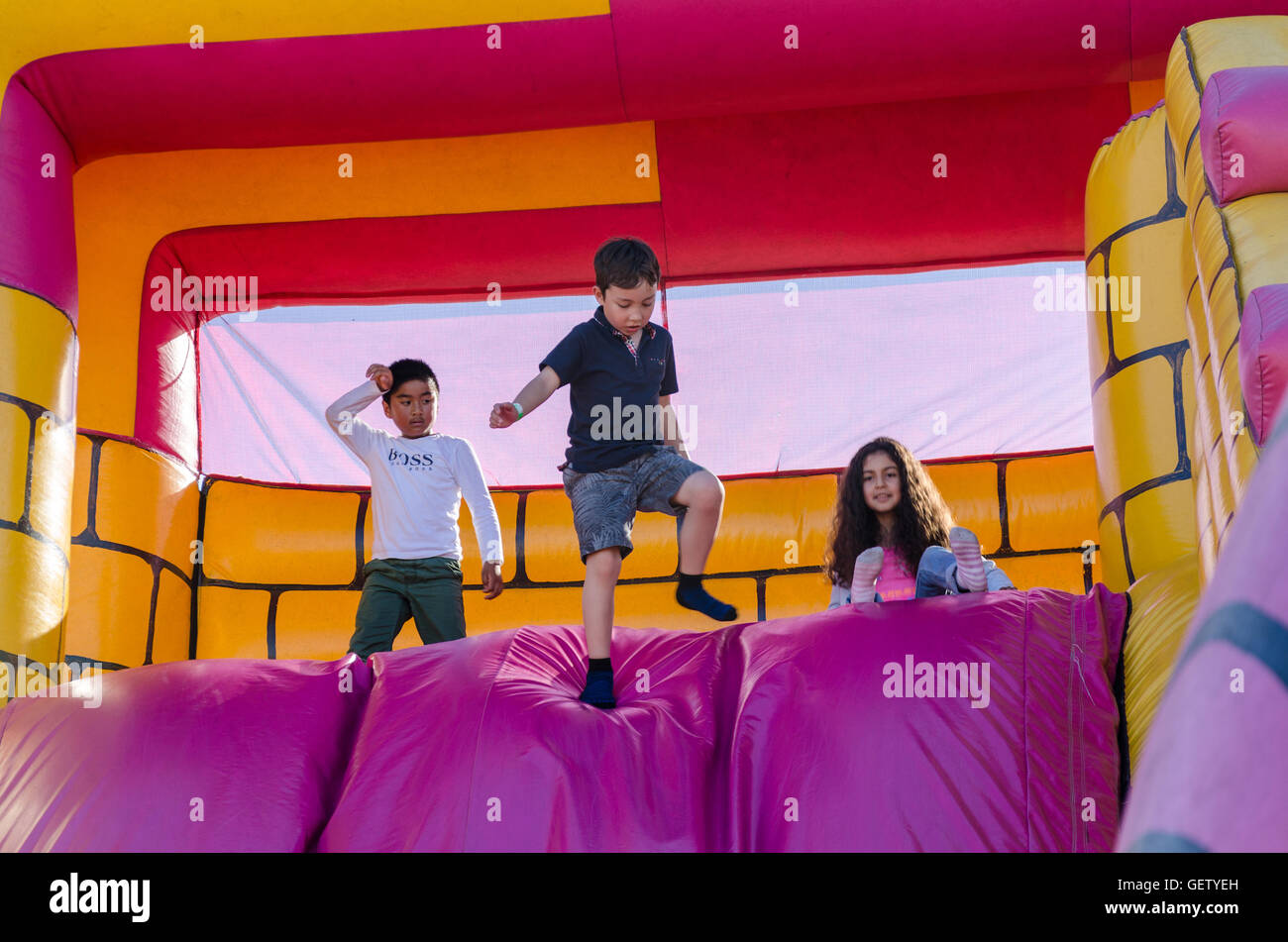 Young children at the top of a large, inflatable slide Stock Photo - Alamy