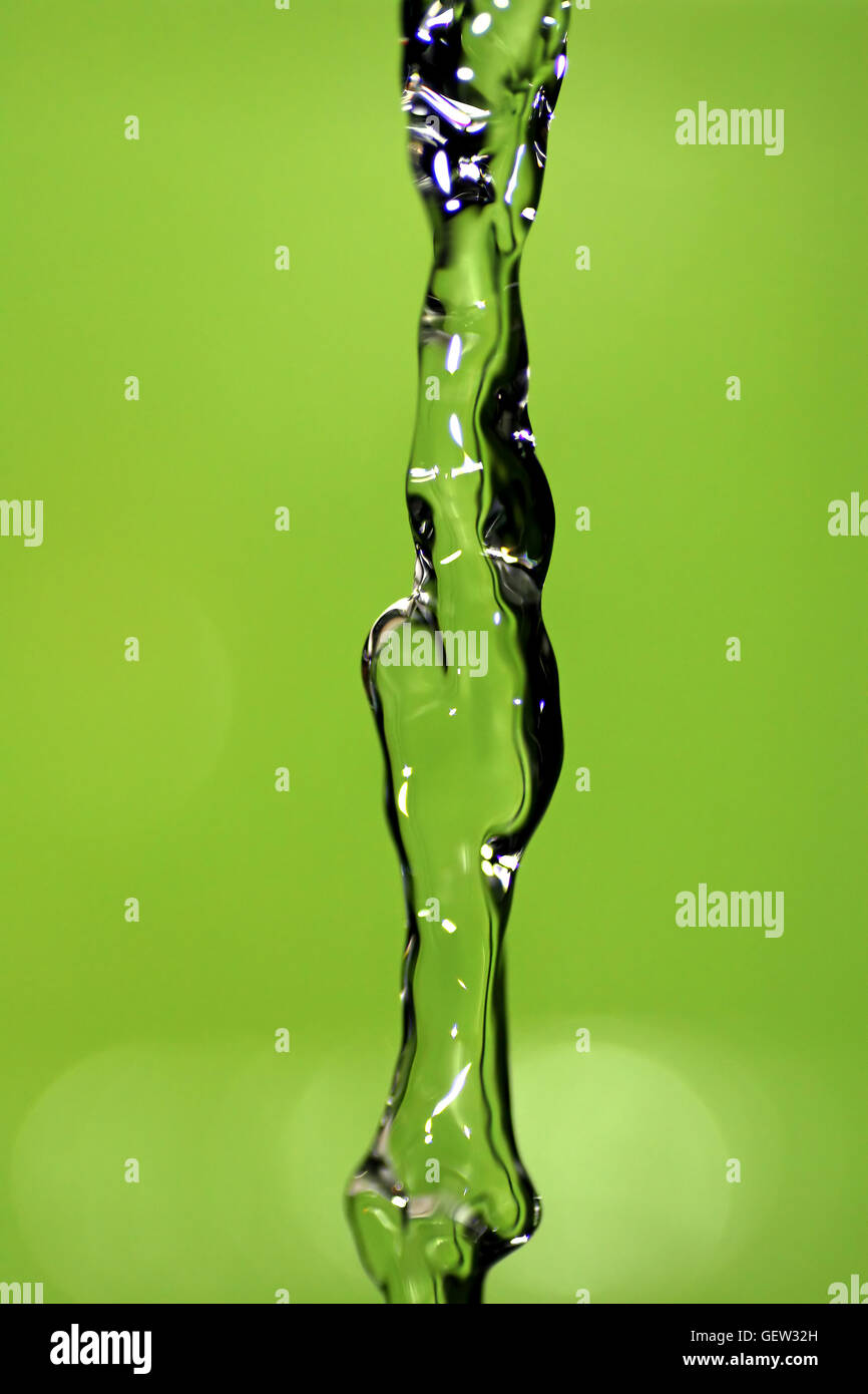 Water falling down, frozen in time with green background Stock Photo ...