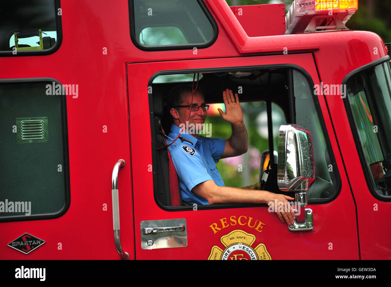 A Canadian fireman waving from the cab of a fire engine during a Pride ...