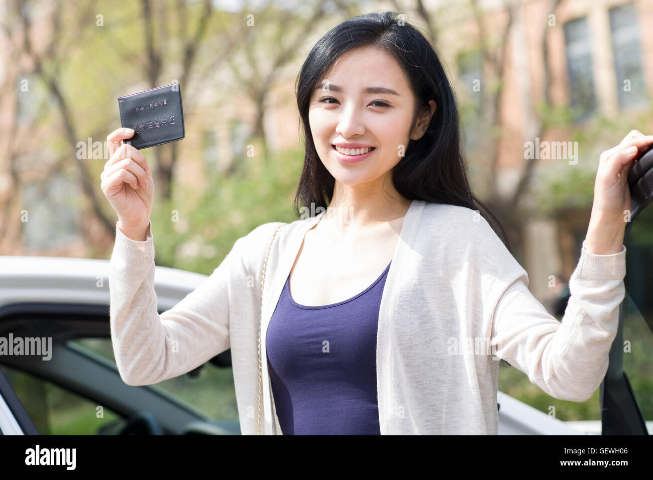 Young Chinese woman showing her driver's license Stock Photo - Alamy