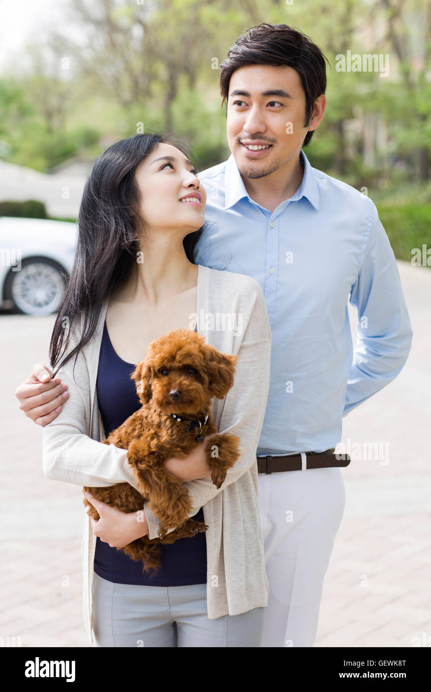Happy young Chinese couple with their pet dog Stock Photo - Alamy