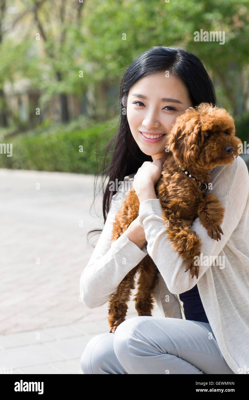 Happy young Chinese woman with her pet dog Stock Photo - Alamy