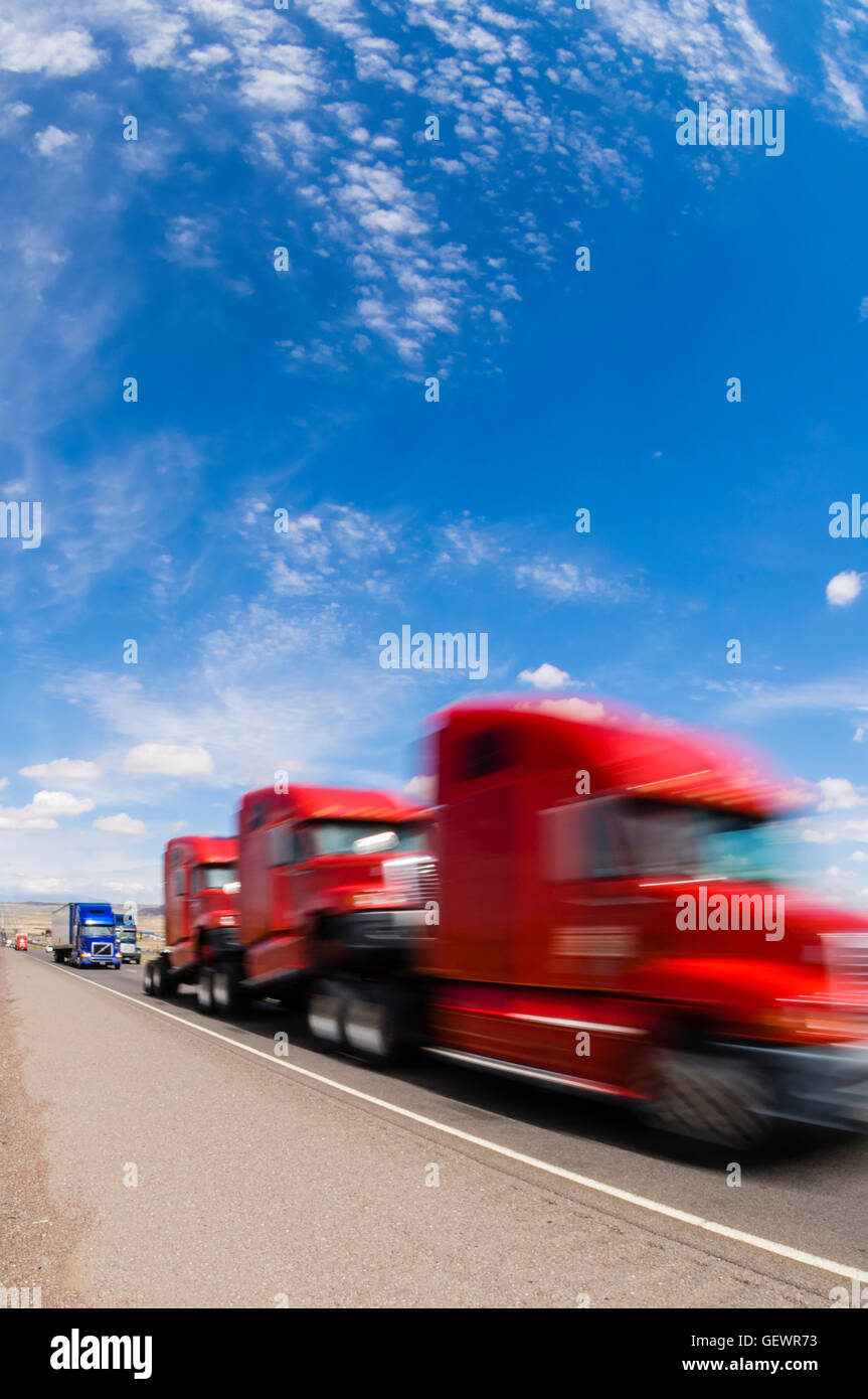 Red truck carrying two further trucks on highway Stock Photo - Alamy
