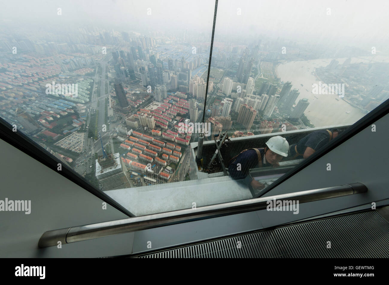 View of man in window cleaning gondola on the glass facade of the ...