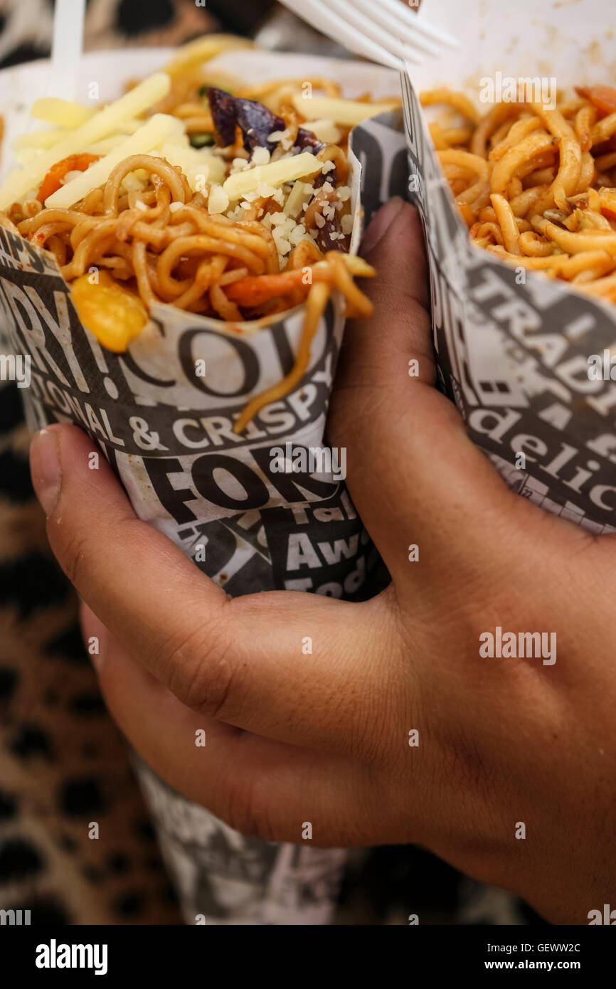 Hand holding cones of fast food noodles Stock Photo - Alamy