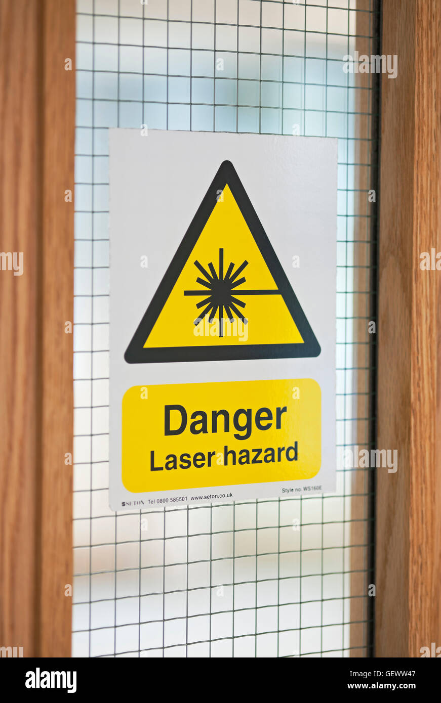 Danger laser hazard sign on glass door panel Stock Photo - Alamy
