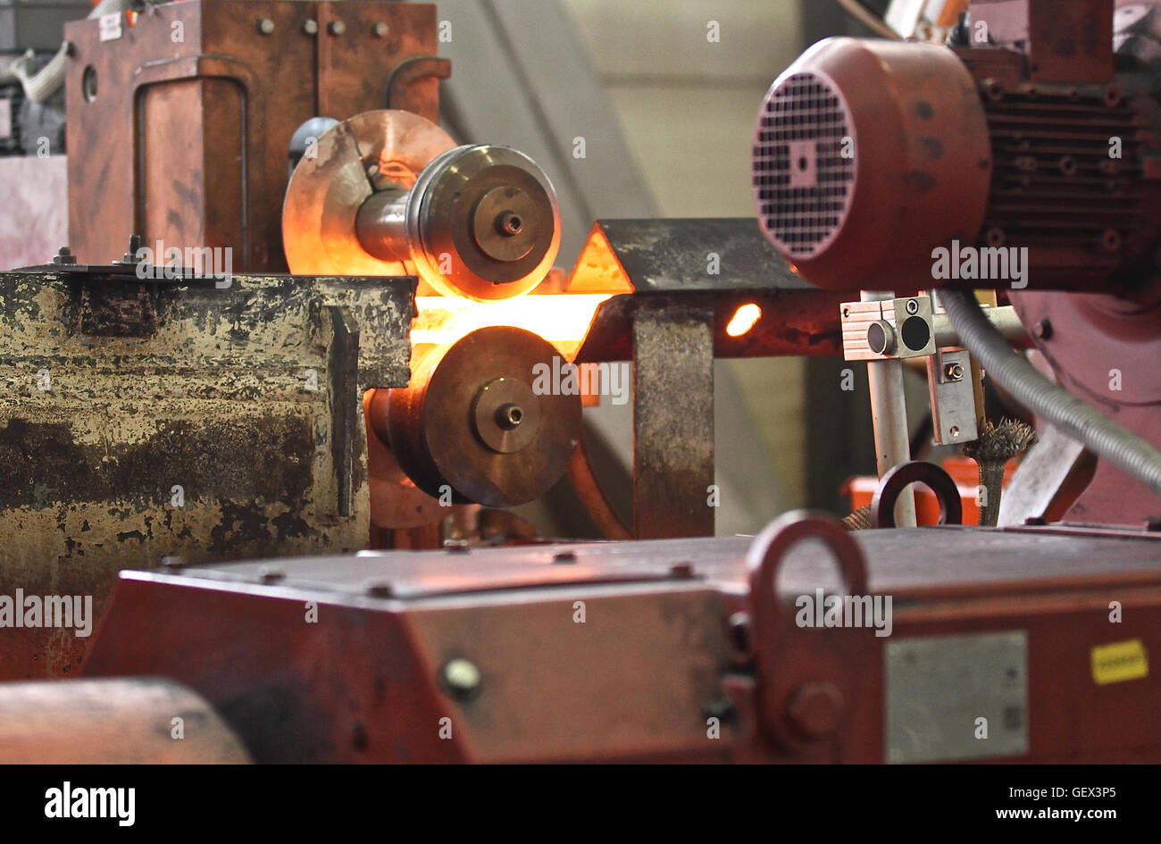 Moving the heated metal rod through the rollers in rolling mill Stock ...
