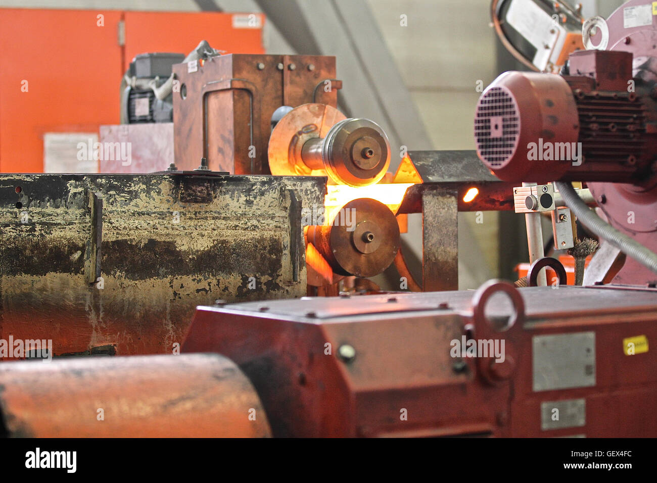 Moving the heated metal rod through the rollers in rolling mill Stock ...