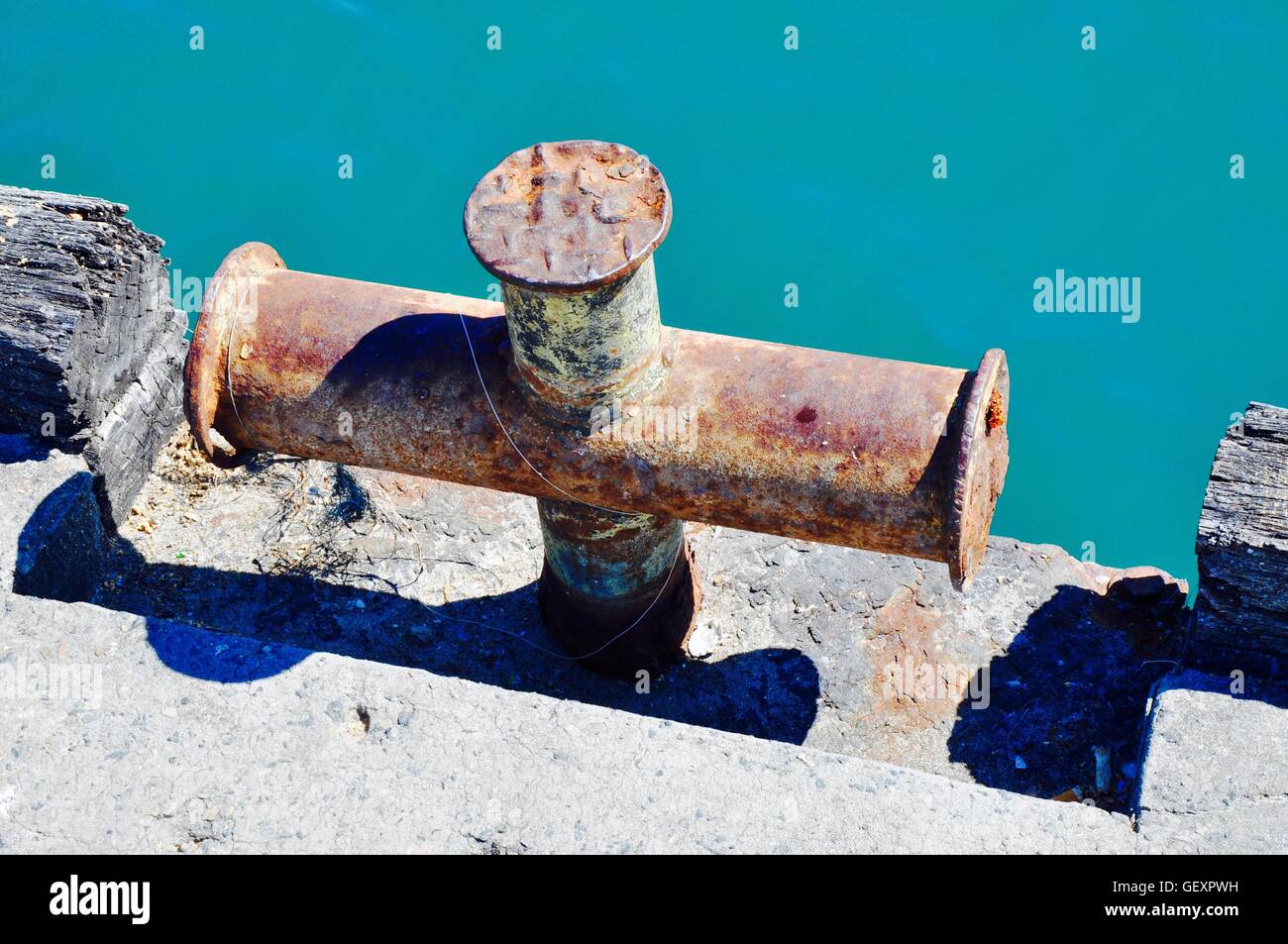 T-shaped permanent metal jetty mooring in concrete with rusted surface ...