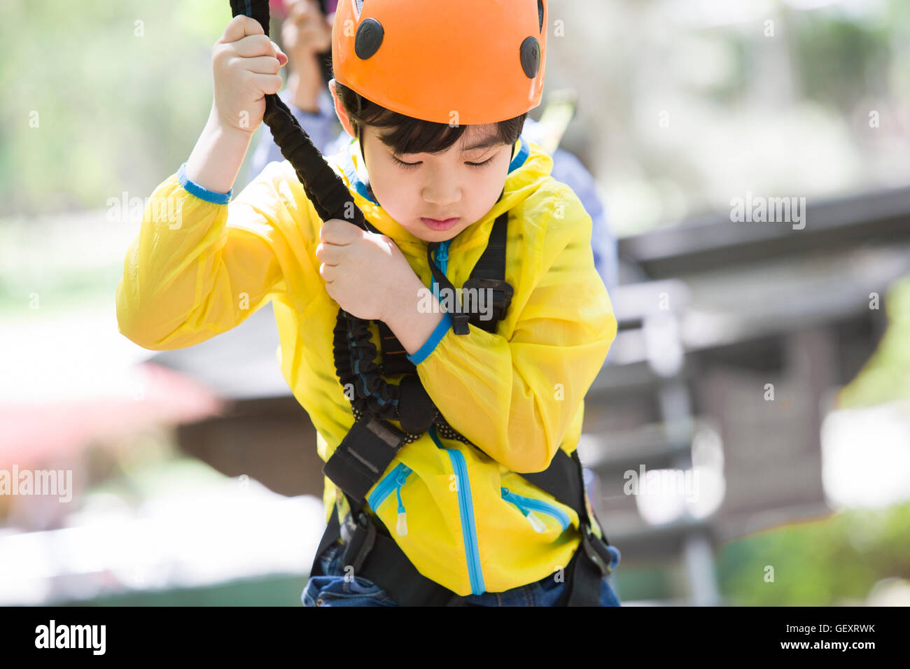 Little Chinese boy playing in tree top adventure park Stock Photo - Alamy