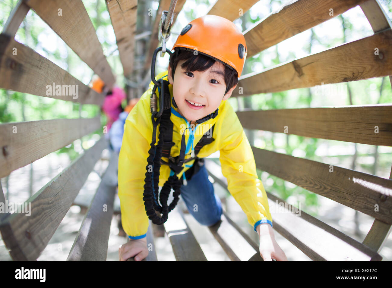 Little Chinese boy playing in tree top adventure park Stock Photo - Alamy