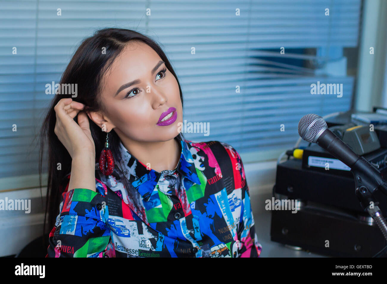 Girl in headphones with a microphone on the radio in the studio Stock ...