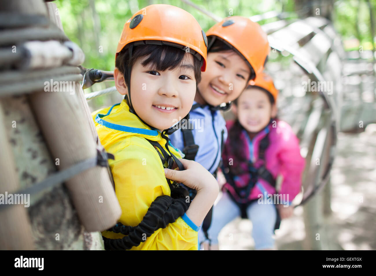 Happy Chinese children playing in tree top adventure park Stock Photo ...