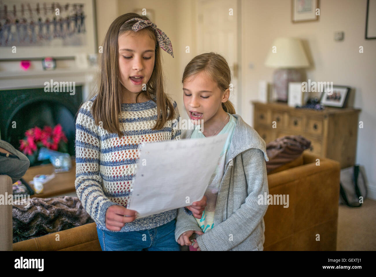 Two children singing from a song sheet Stock Photo - Alamy