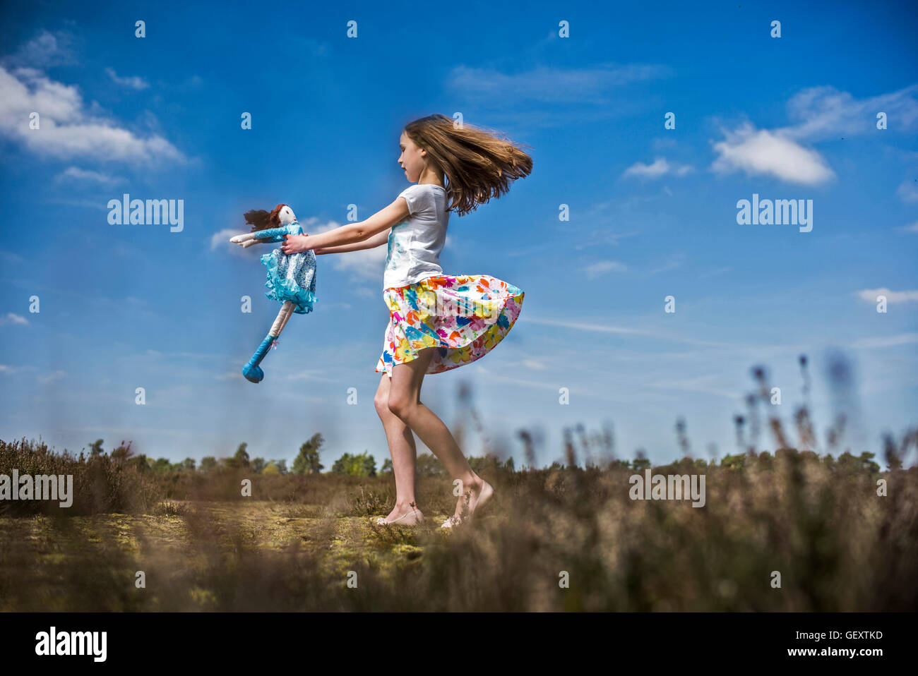 A young girl dancing with a doll in the open air Stock Photo - Alamy