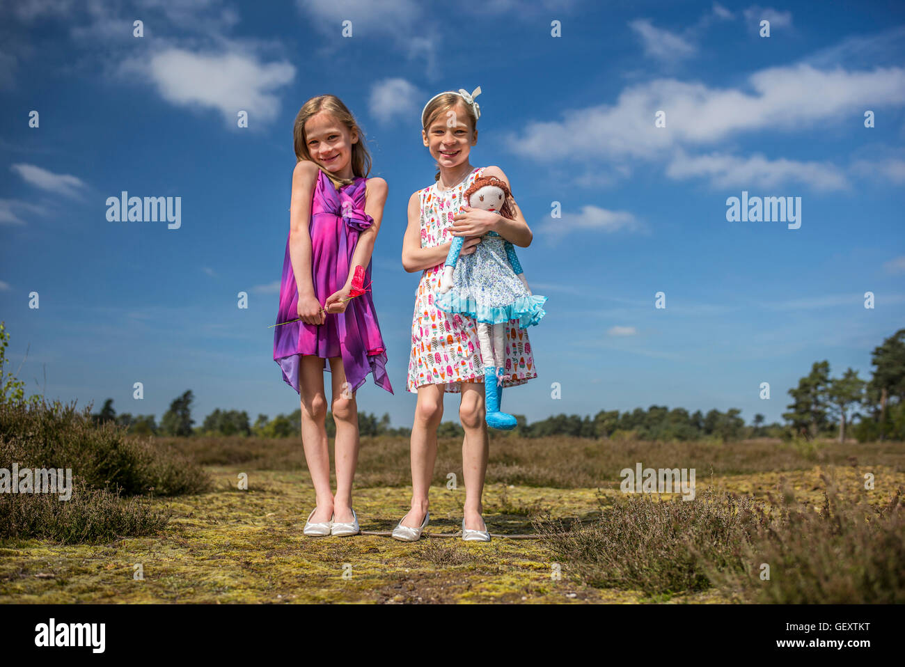Identical twin sisters play together in the open air Stock Photo - Alamy
