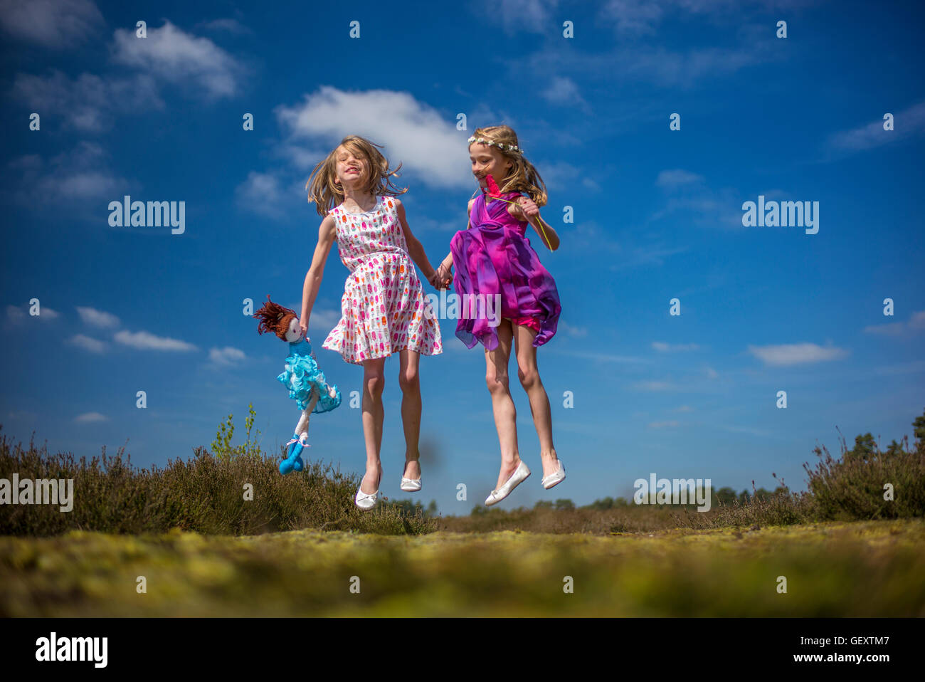 Identical twin sisters play together in the open air Stock Photo - Alamy