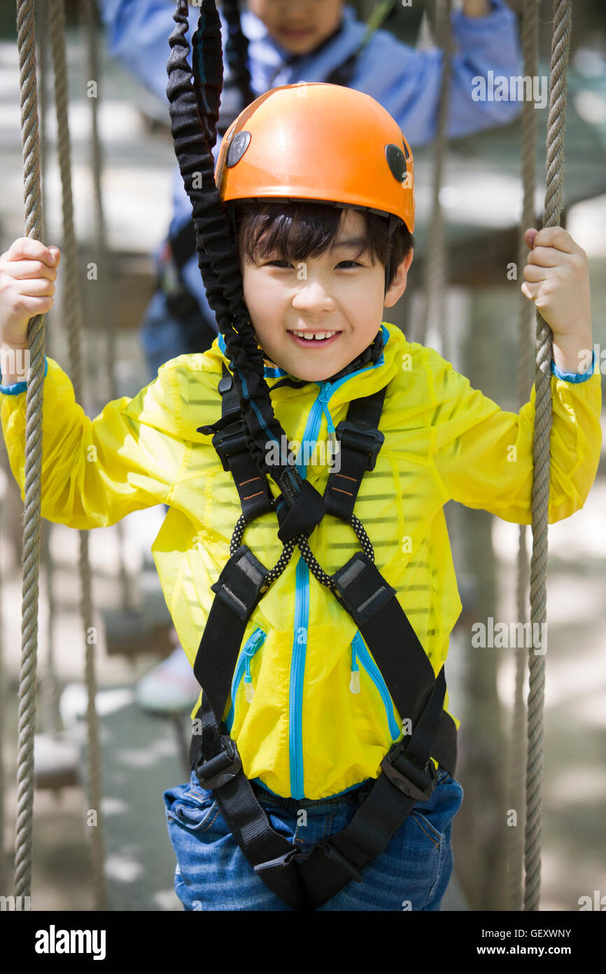 Little Chinese boy playing in tree top adventure park Stock Photo - Alamy