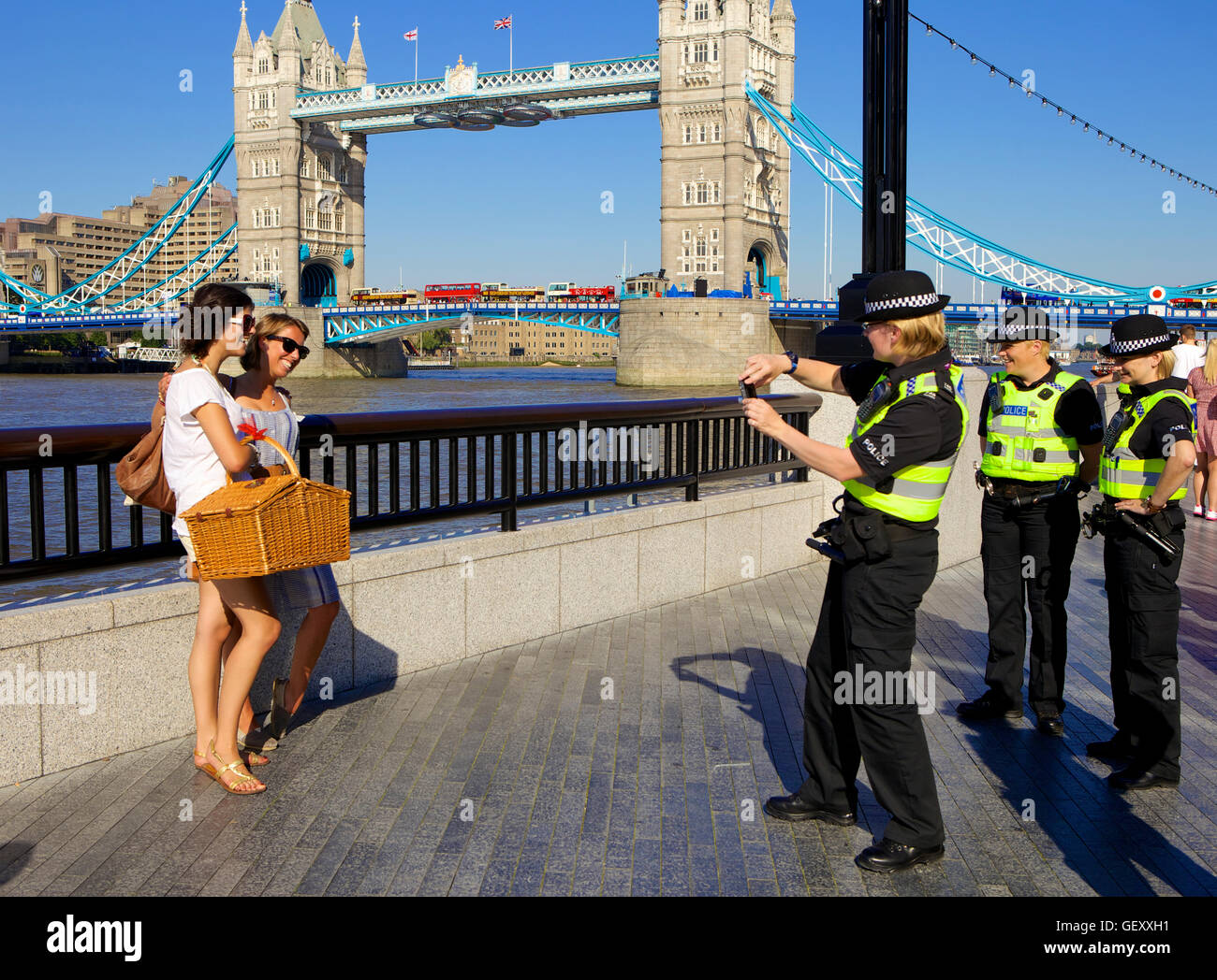 Female police officers taking pictures of tourists in front of Tower ...