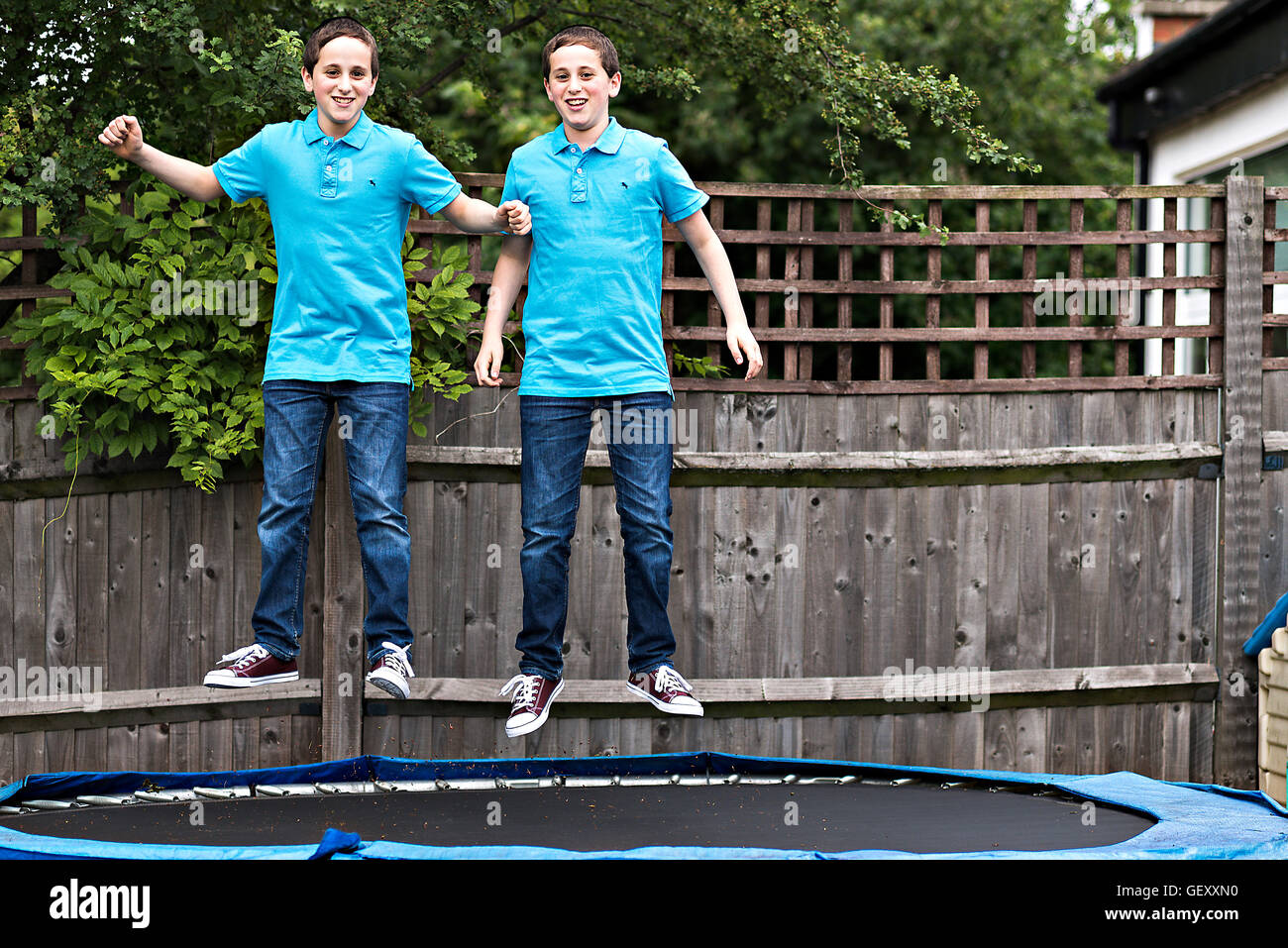 Young twin brothers jumping on a trampoline Stock Photo - Alamy