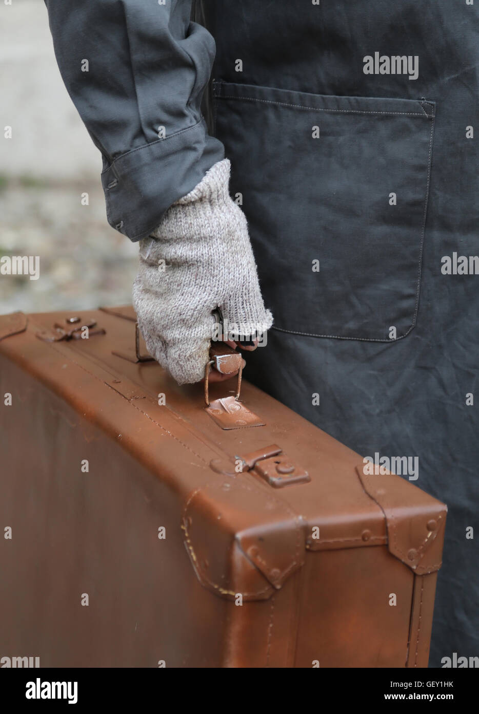 poor immigrant with old leather suitcase and broken gloves during the ...