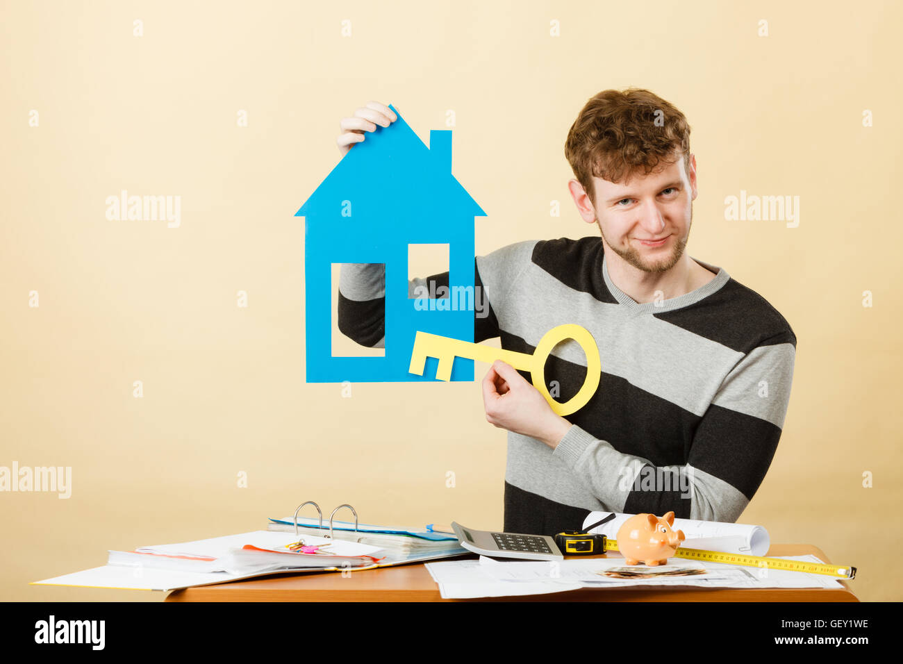 Good purchase concept. Male buyer with paper model of house and key ...