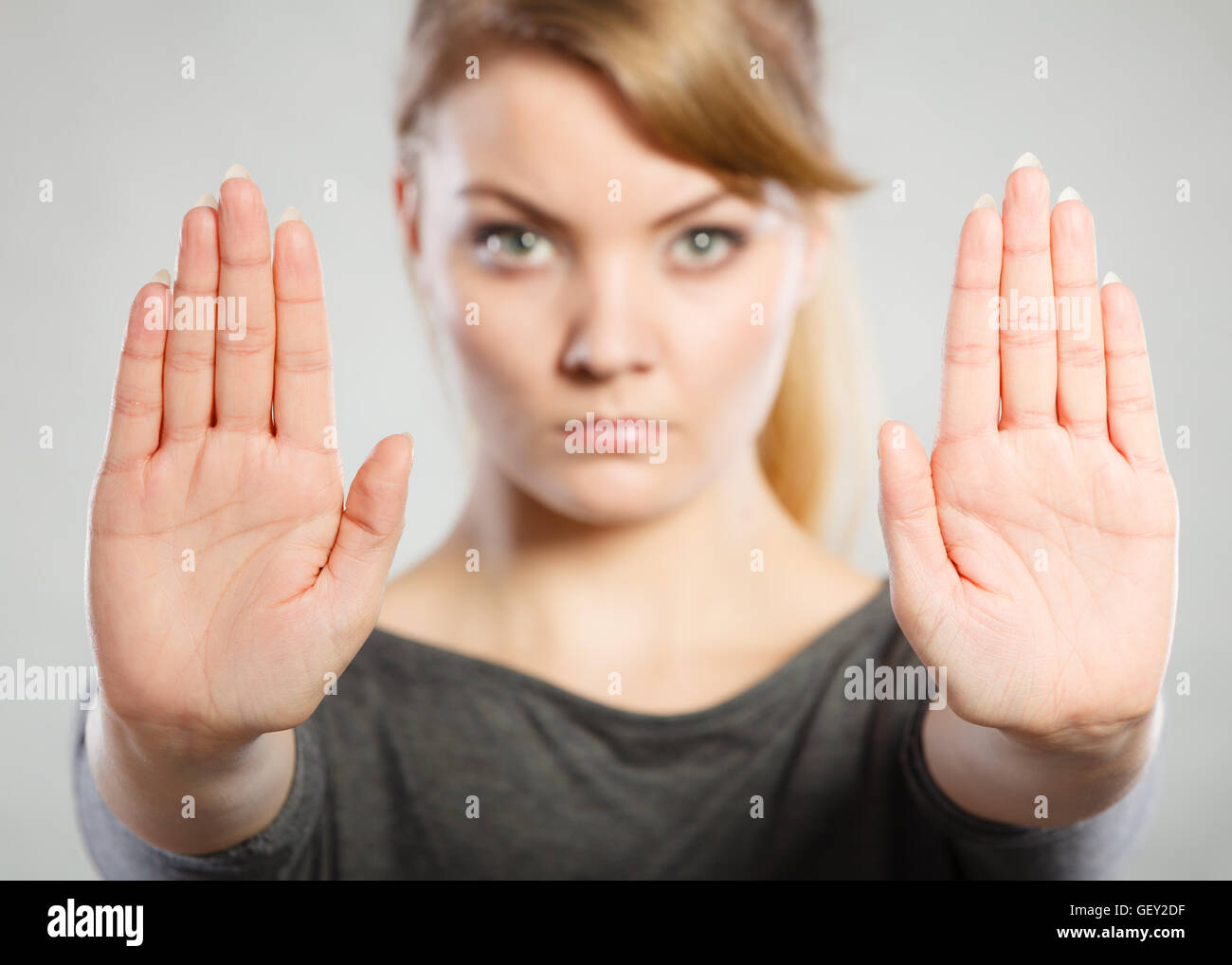 Prohibition symbol. Serious female shows stop sign talk to hand gesture ...