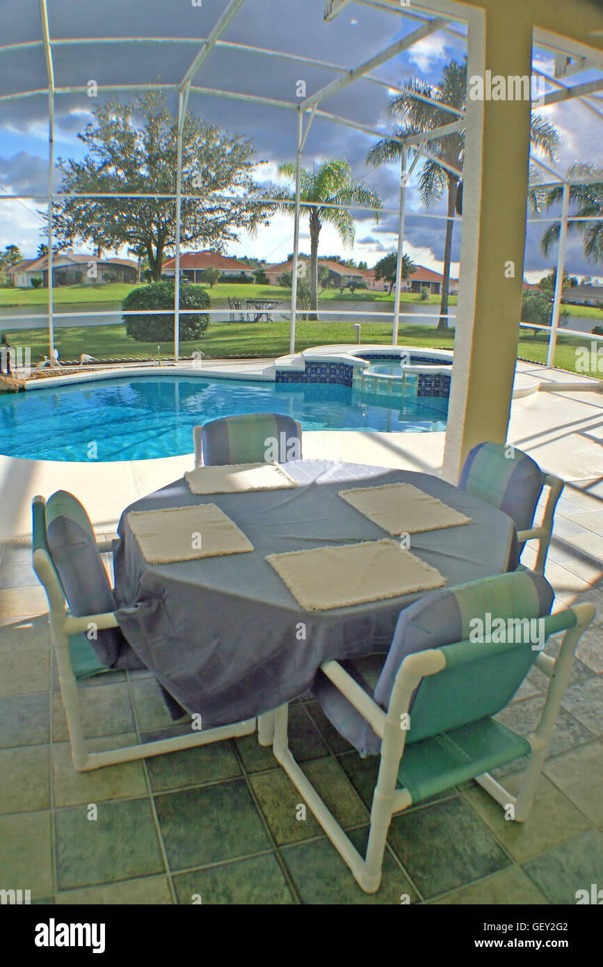 A view from a lanai of a pool, spa and lake Stock Photo - Alamy