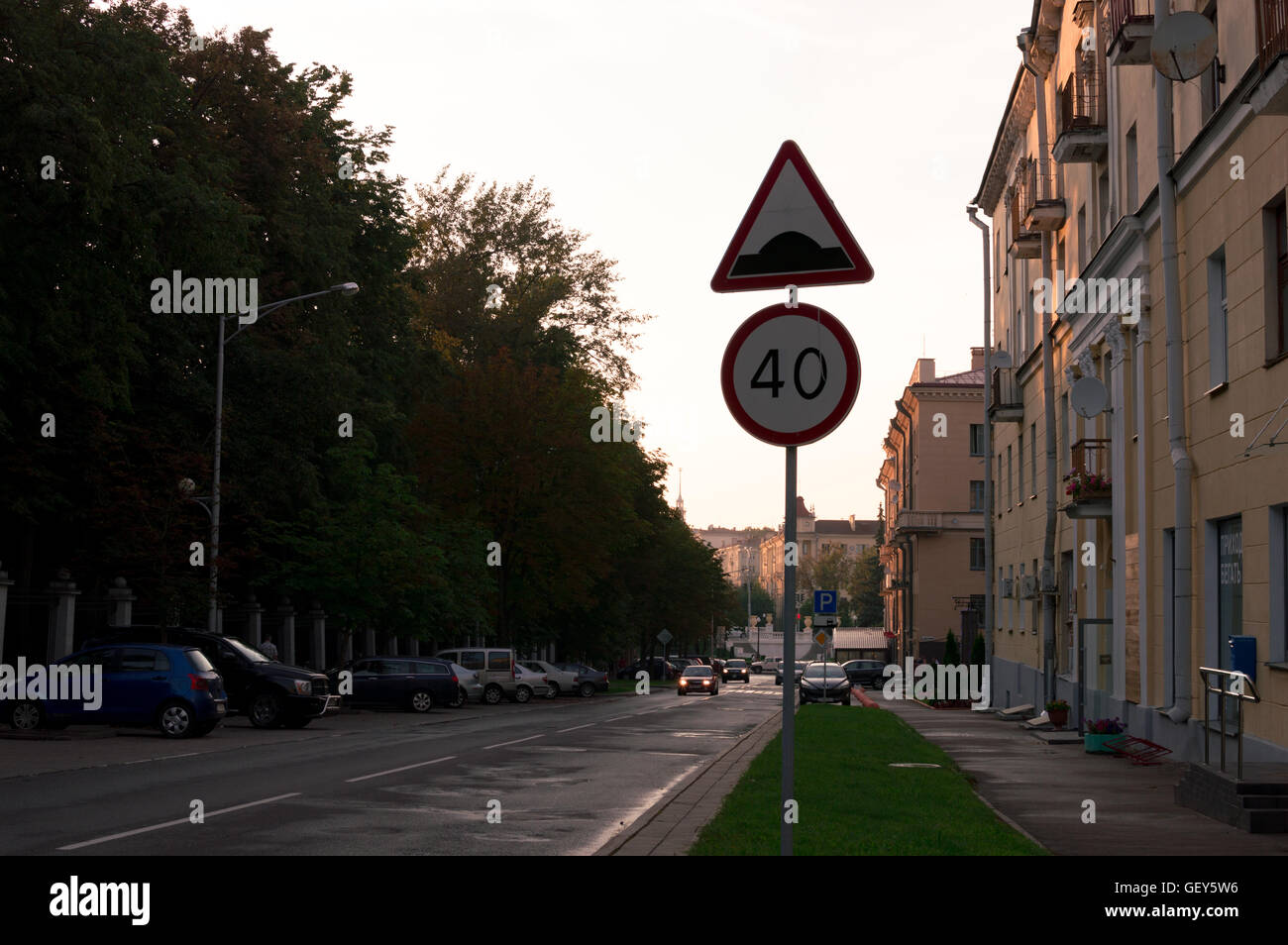 Traffic sign with speed limit on quite city street at sunset. Green ...