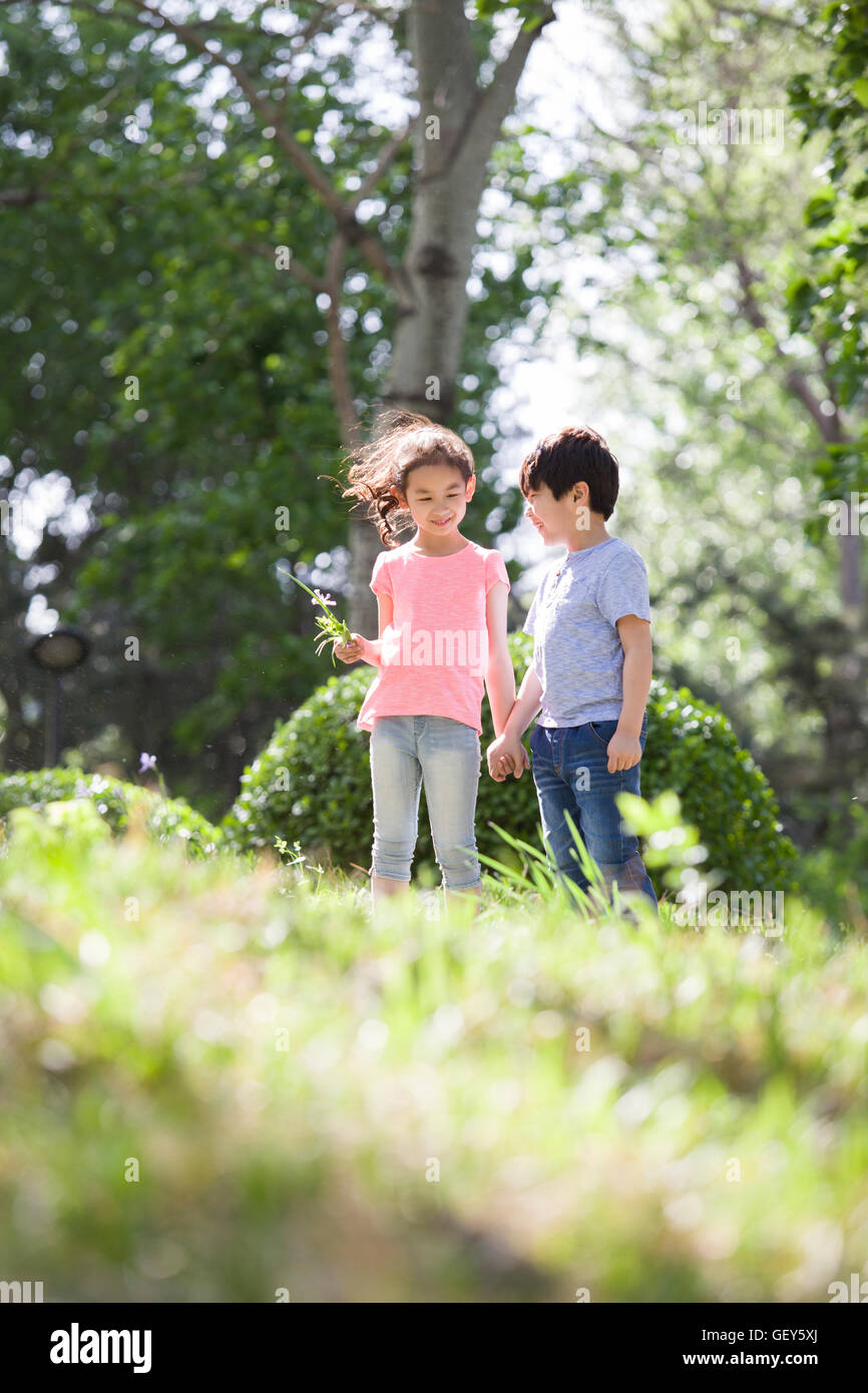 Happy Chinese children holding hands in woods Stock Photo - Alamy