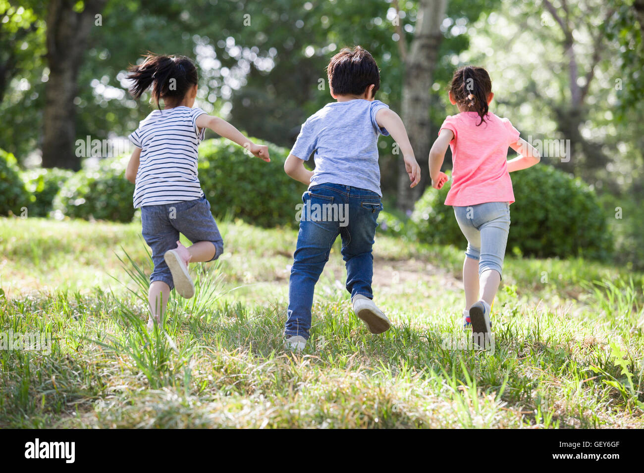 Happy Chinese children running in woods Stock Photo - Alamy