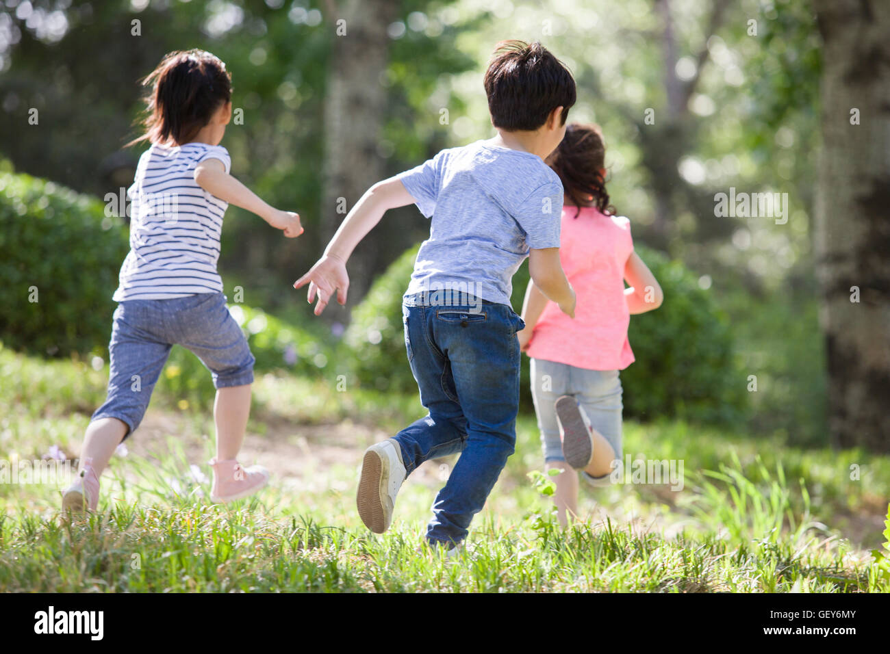 Happy Chinese children running in woods Stock Photo - Alamy