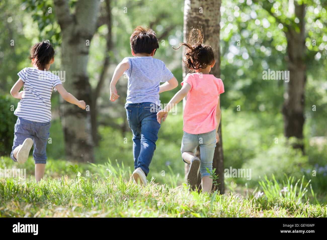 Happy Chinese children running in woods Stock Photo - Alamy