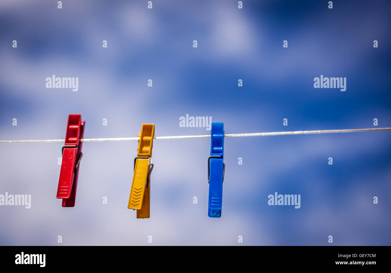Three colorful laundry clips hanging on a cloths line Stock Photo - Alamy