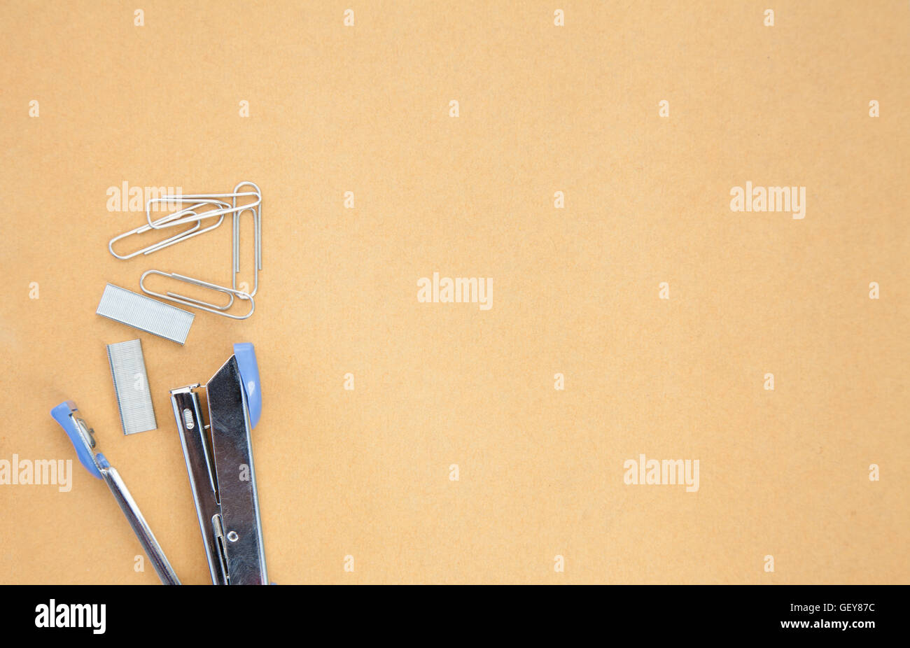 staples and stapler placed on brown paper background, leave space for ...