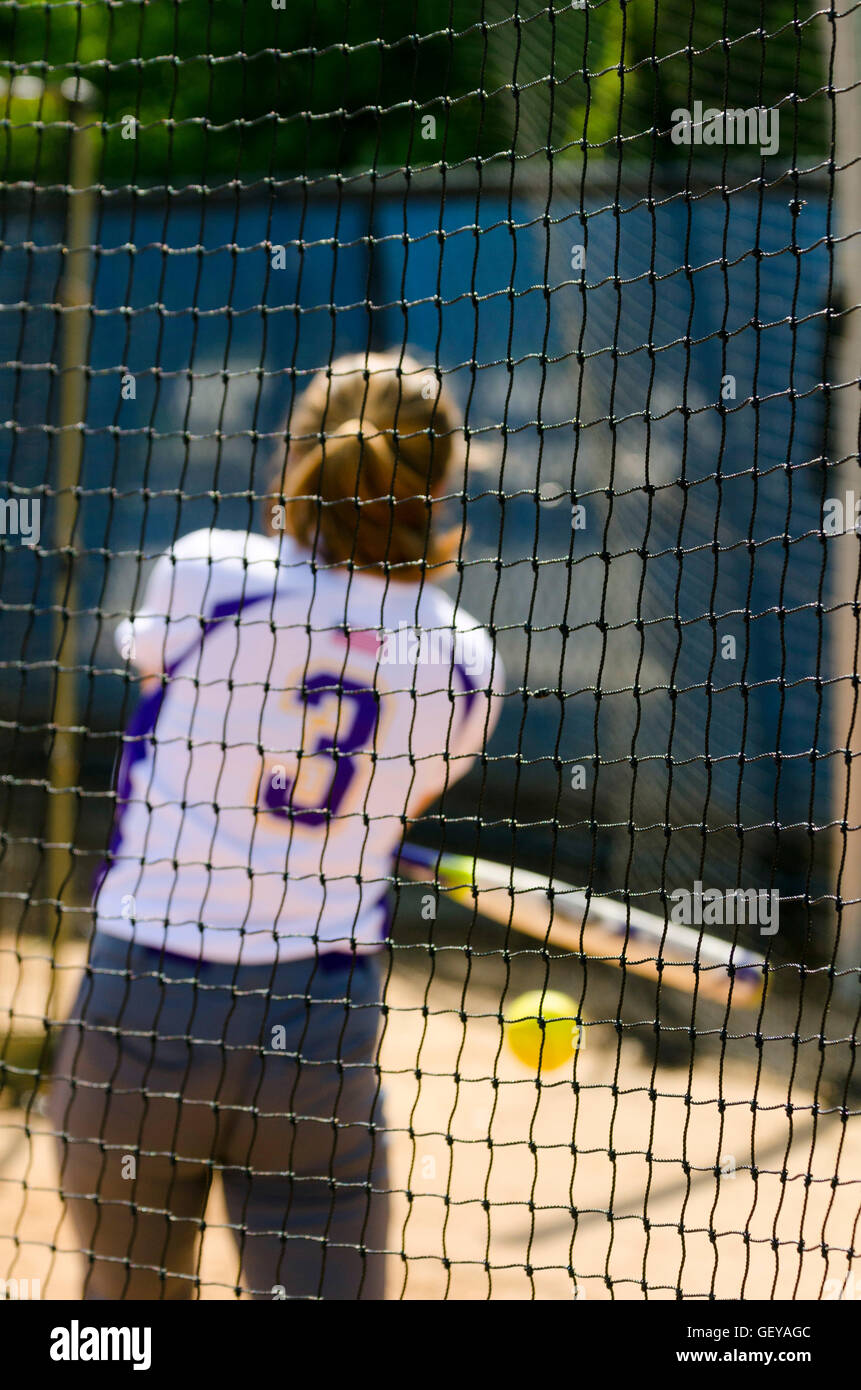 Girl practicing in batter's cage Stock Photo - Alamy