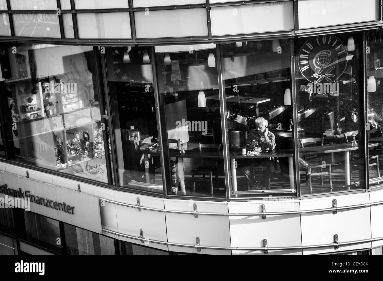 A man relaxing in a window seat at a shopping mall cafe in Steglitz ...