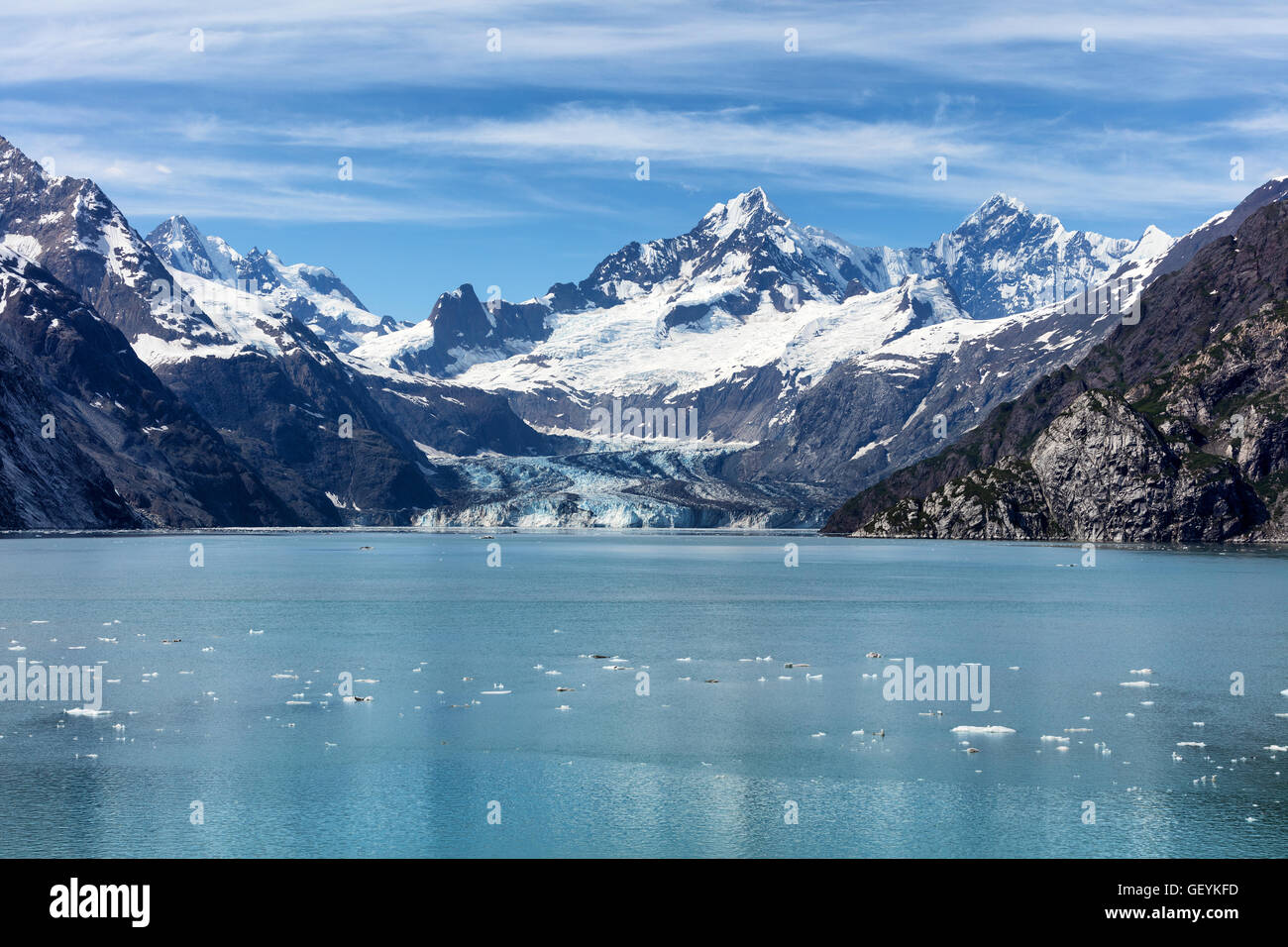 Alaskan glacier flowing into bay with floating ice and water in ...