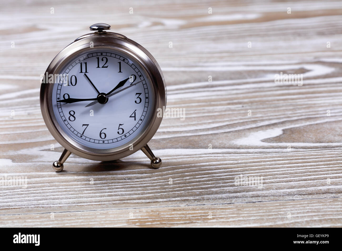 Retro table clock on faded white wooden boards Stock Photo - Alamy