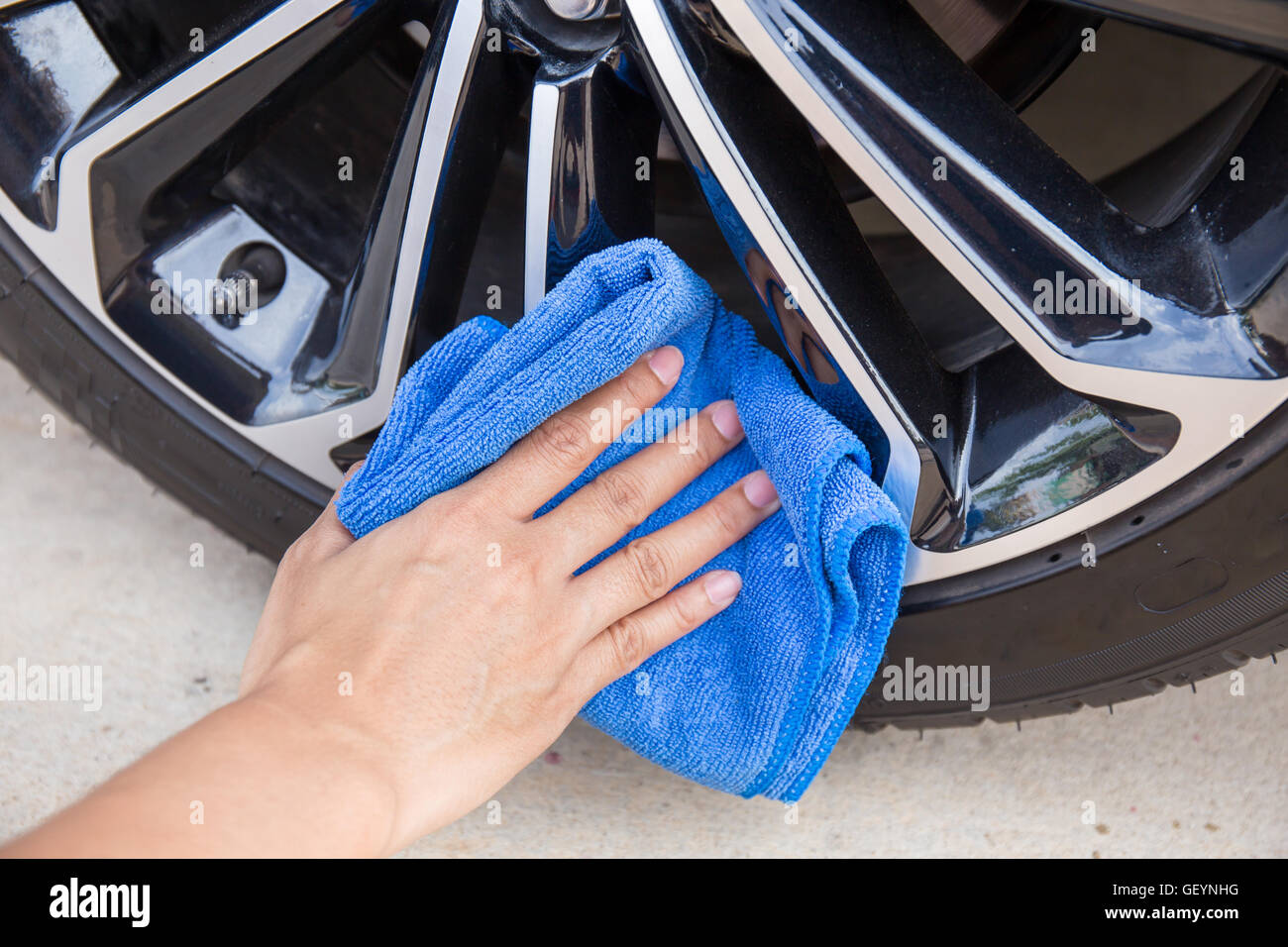 Hand with blue microfiber cloth cleaning car wheel Stock Photo - Alamy