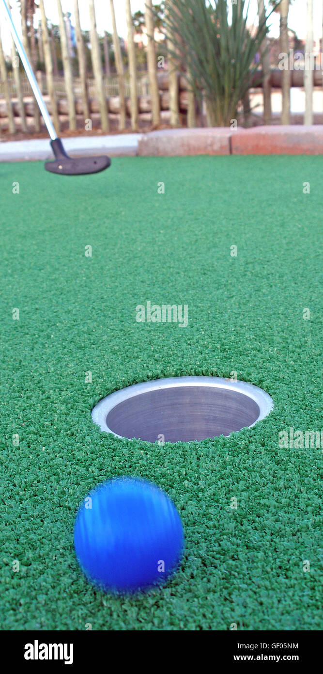 Putting a ball at an adventure golf Stock Photo - Alamy